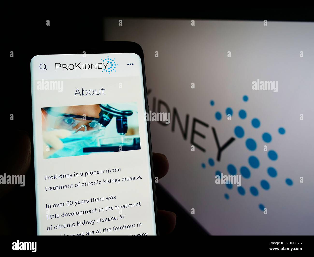 Person holding cellpohone with webpage of US healthcare company ...
