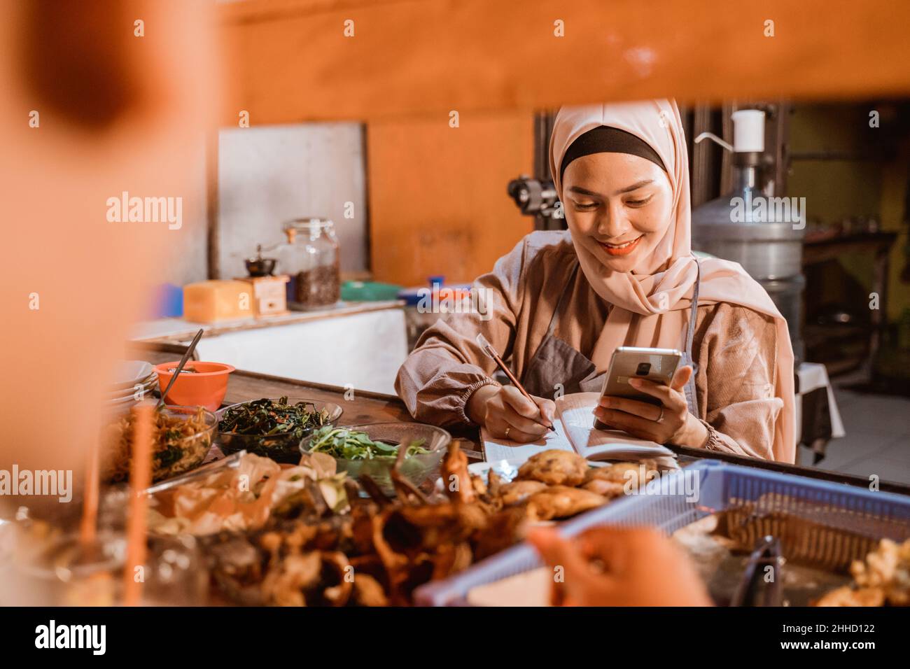 woman small business owner using mobile phone and write Stock Photo - Alamy