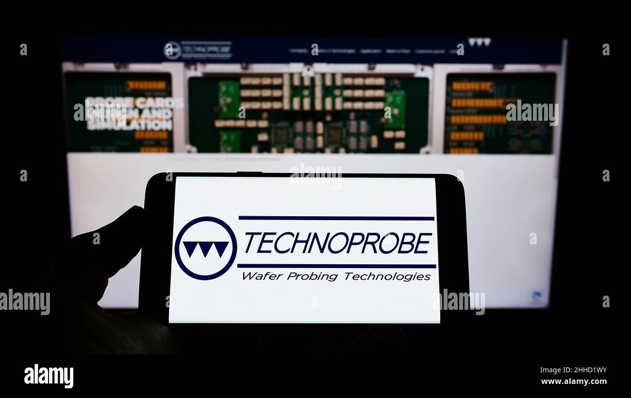 Person holding mobile phone with logo of Italian semiconductor company Technoprobe S.p.A. on ...
