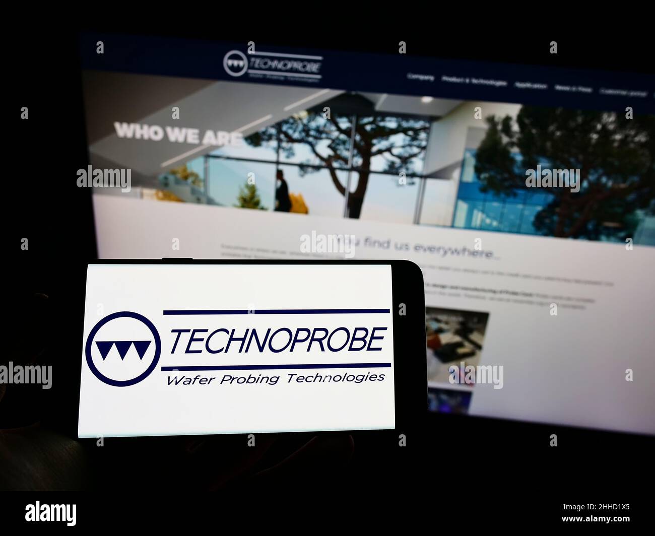 Person holding cellphone with logo of Italian semiconductor company Technoprobe S.p.A. on screen ...