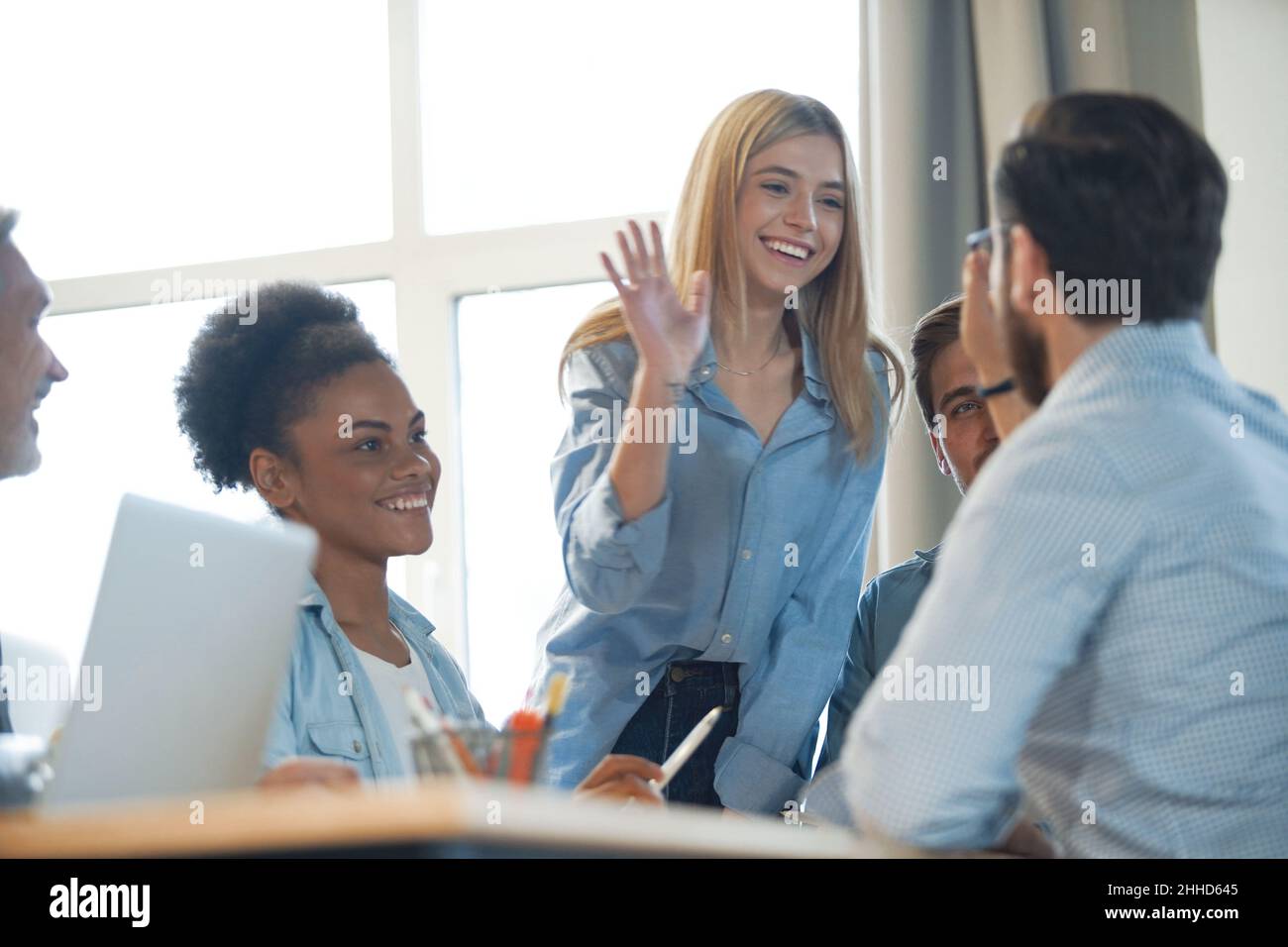 Two cheerful young business people giving high-five while their ...