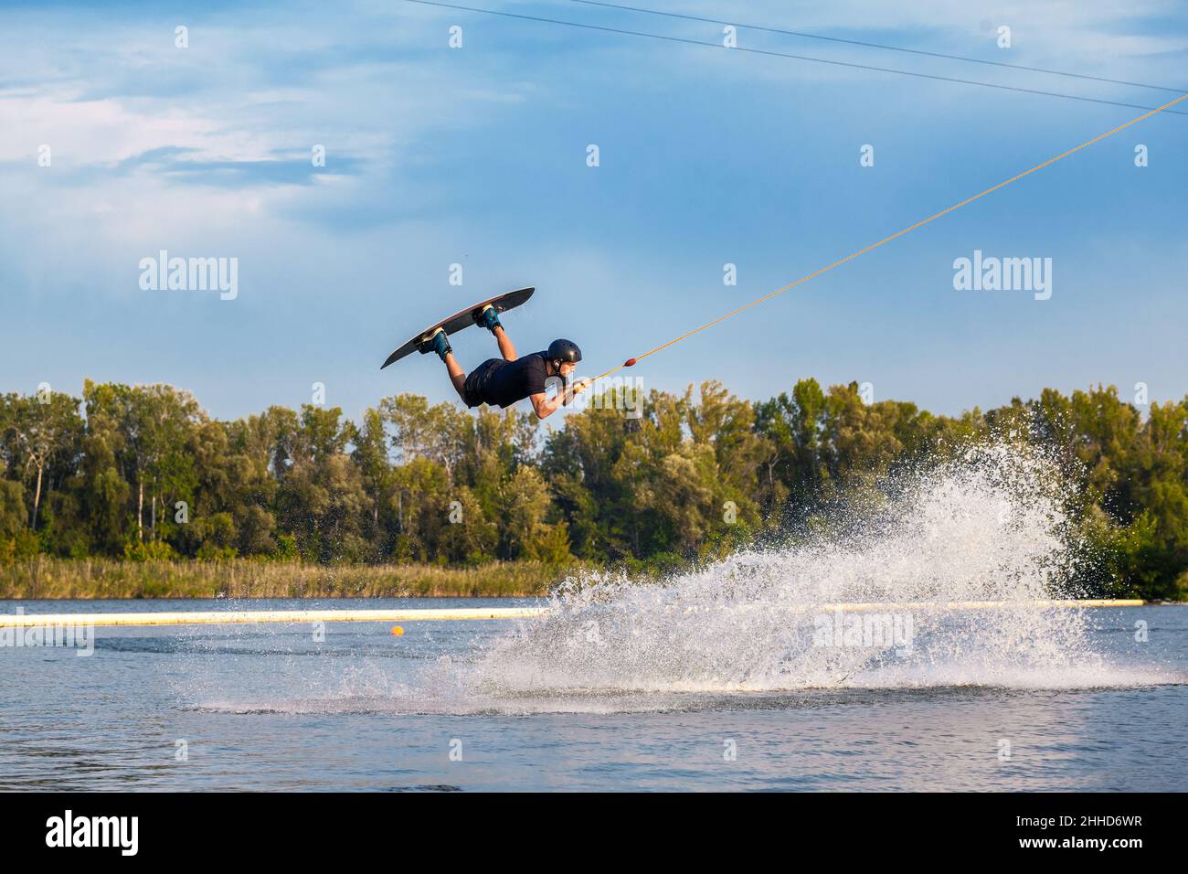 Confident man masterfully jumping over water surface of river on ...