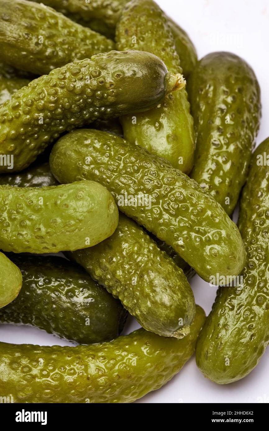 Pile of of Tasty canned Whole green cornichons isolated on a white ...