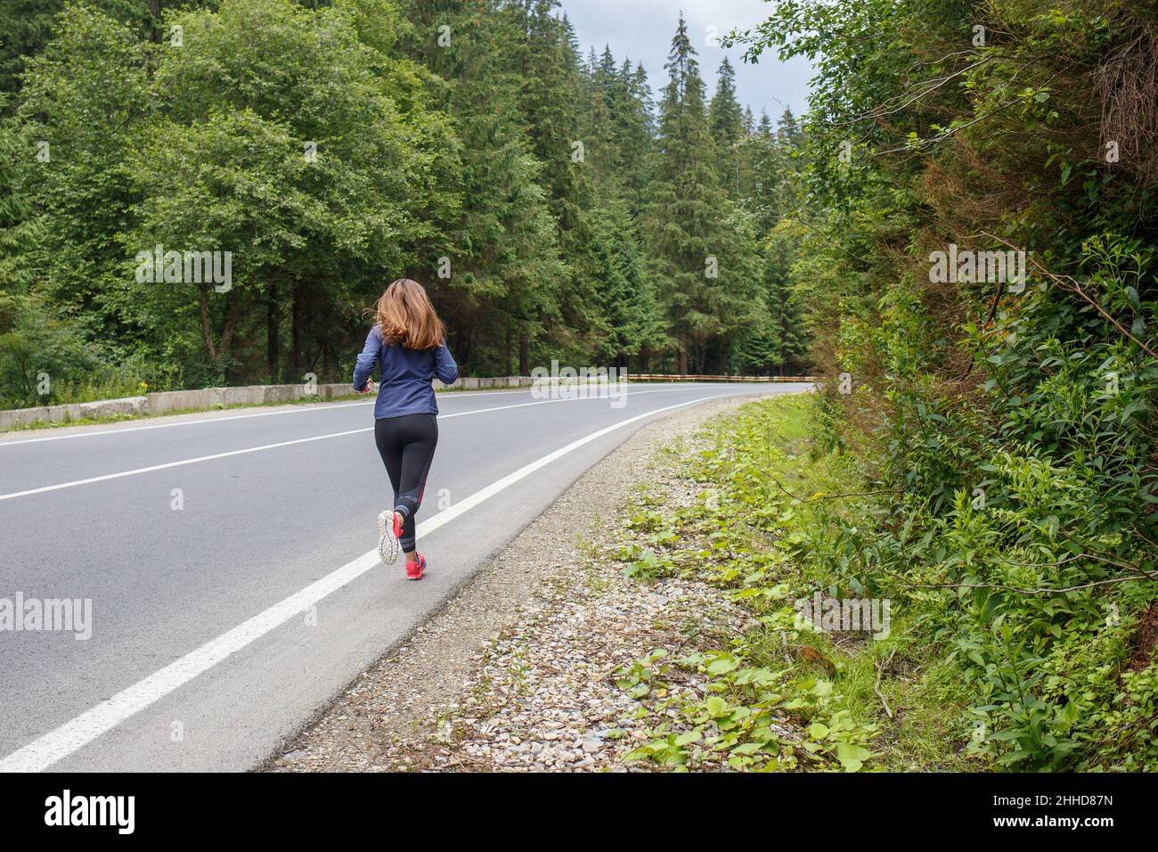Runner woman running on the mountain road through the forest Stock ...