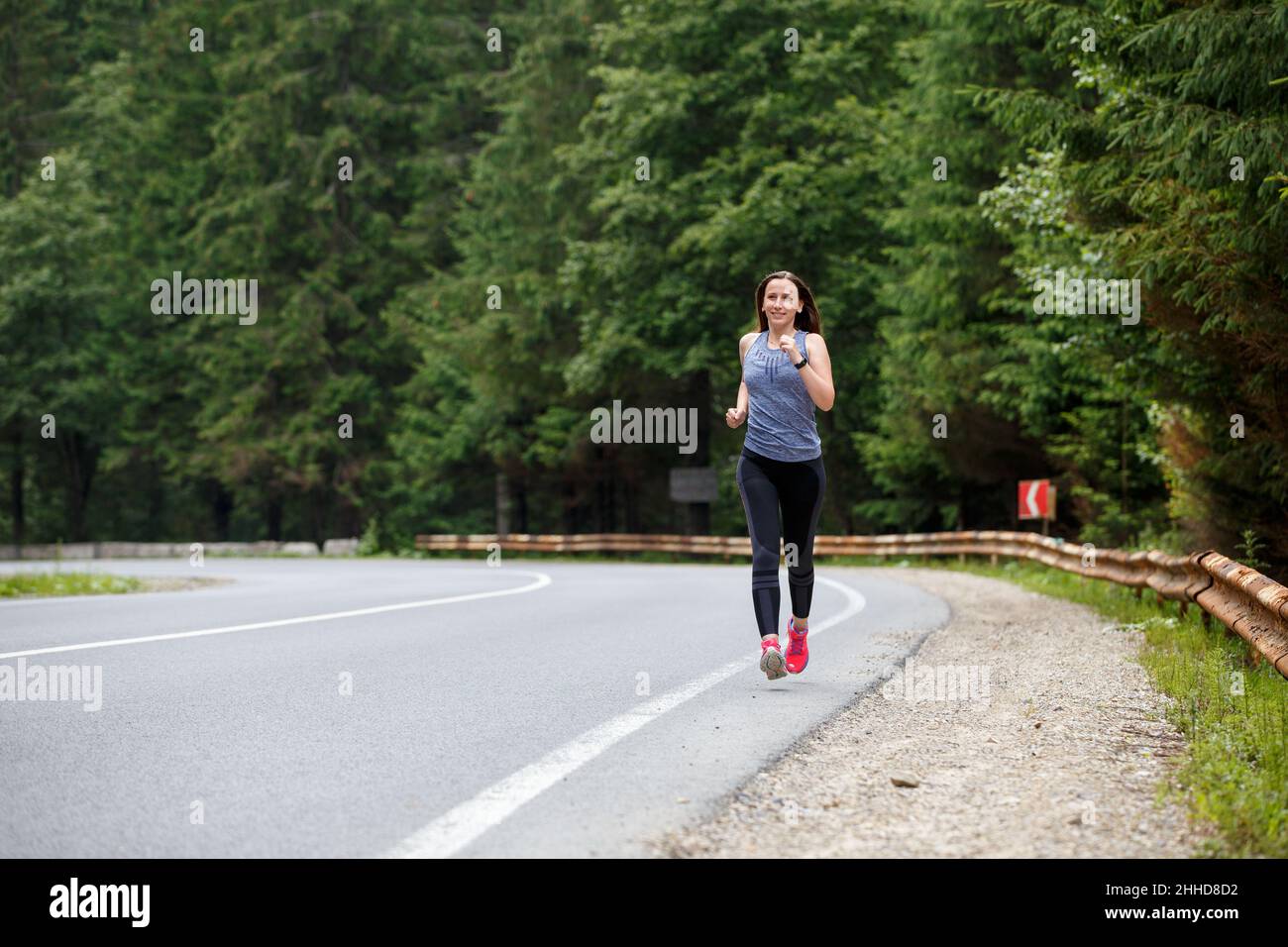 Runner woman running on the mountain road through the forest Stock ...