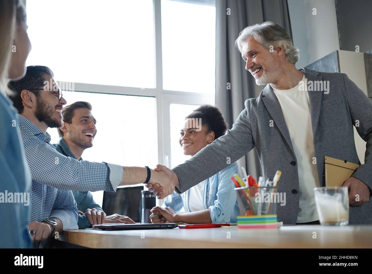 Great job. Two cheerful business men shaking hands while their ...