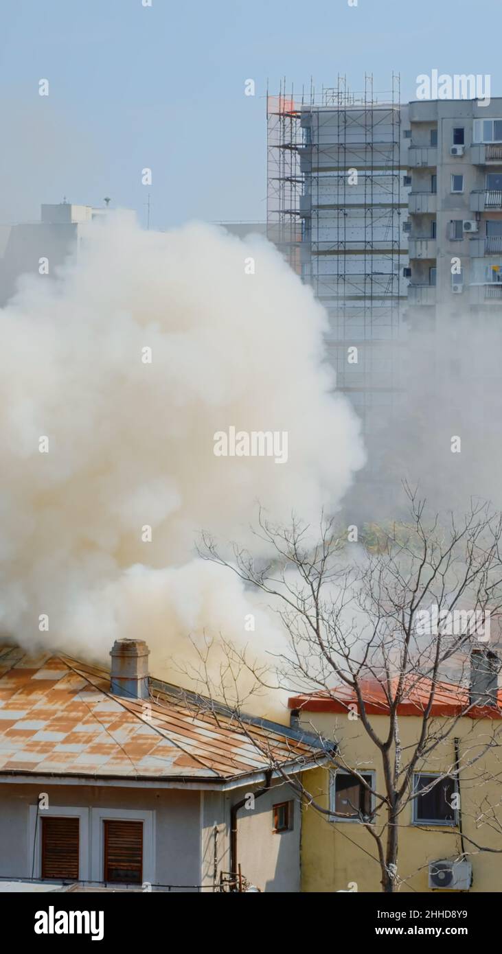 Flames going out from burning house in neighbourhood. Smoke emerging ...