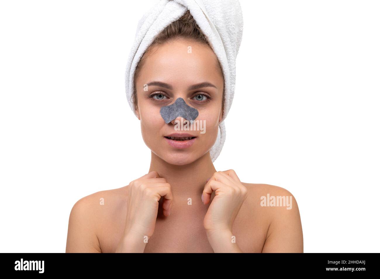 portrait of a young woman after a shower with a cloth mask on her face ...