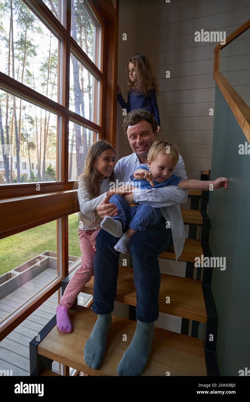 Positive delighted father spending time with kids Stock Photo - Alamy