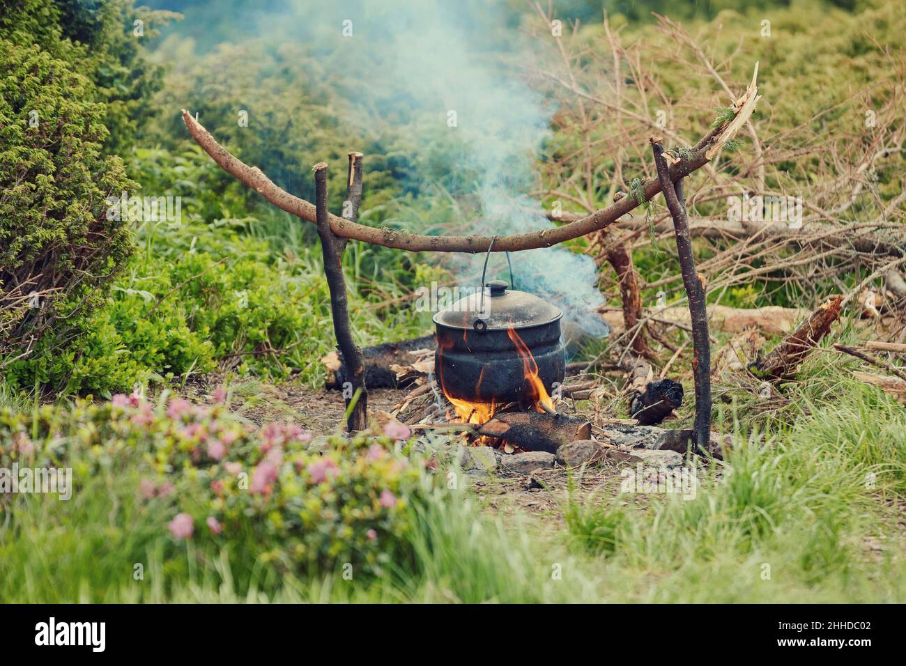 Cooking in field conditions, boiling pot at the campfire on picnic ...