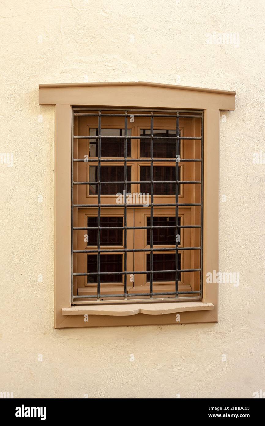 Window in wall with bars. Frame with glass behind bars Stock Photo - Alamy