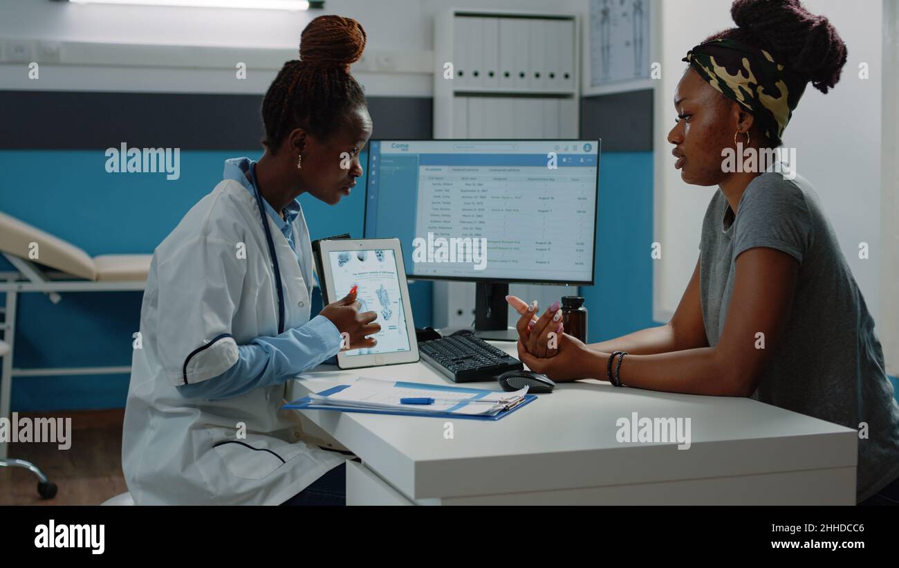 Doctor explaining orthopedic image with human skeleton on tablet for ...