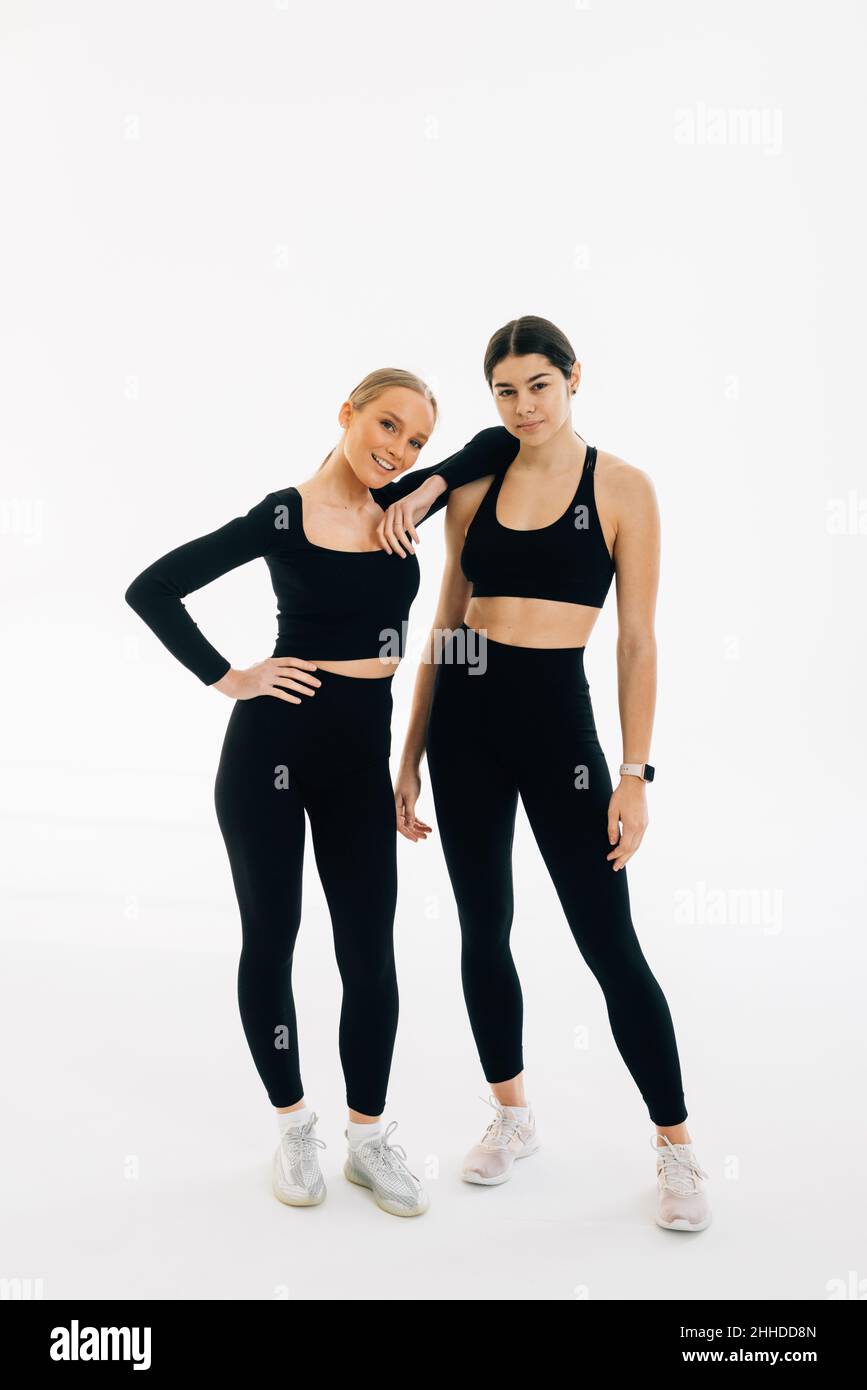 Portrait of two fit women standingover white background Stock Photo - Alamy