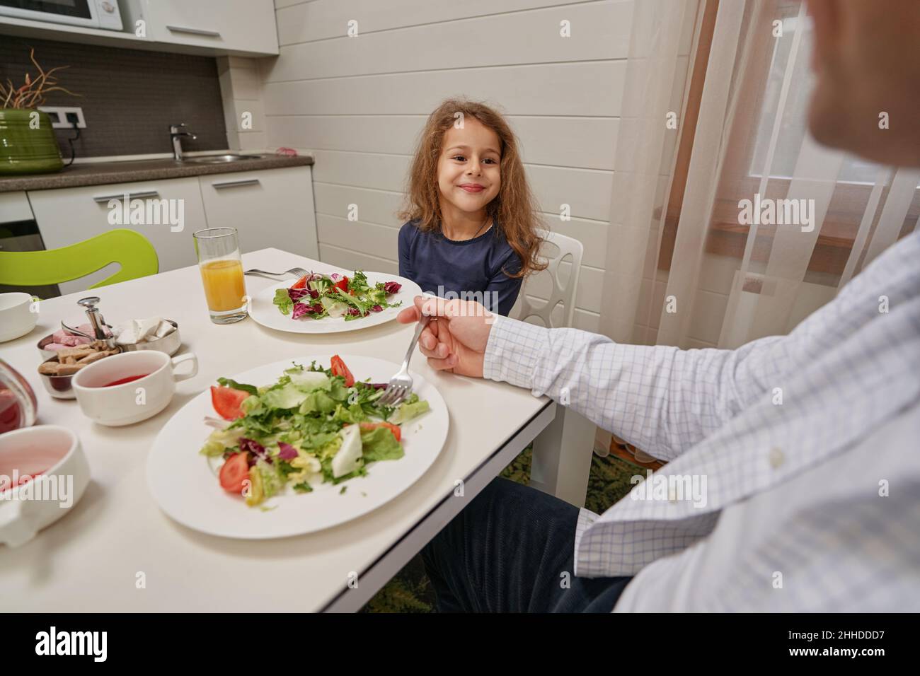 Positive delighted little girl smiling to her daddy Stock Photo - Alamy