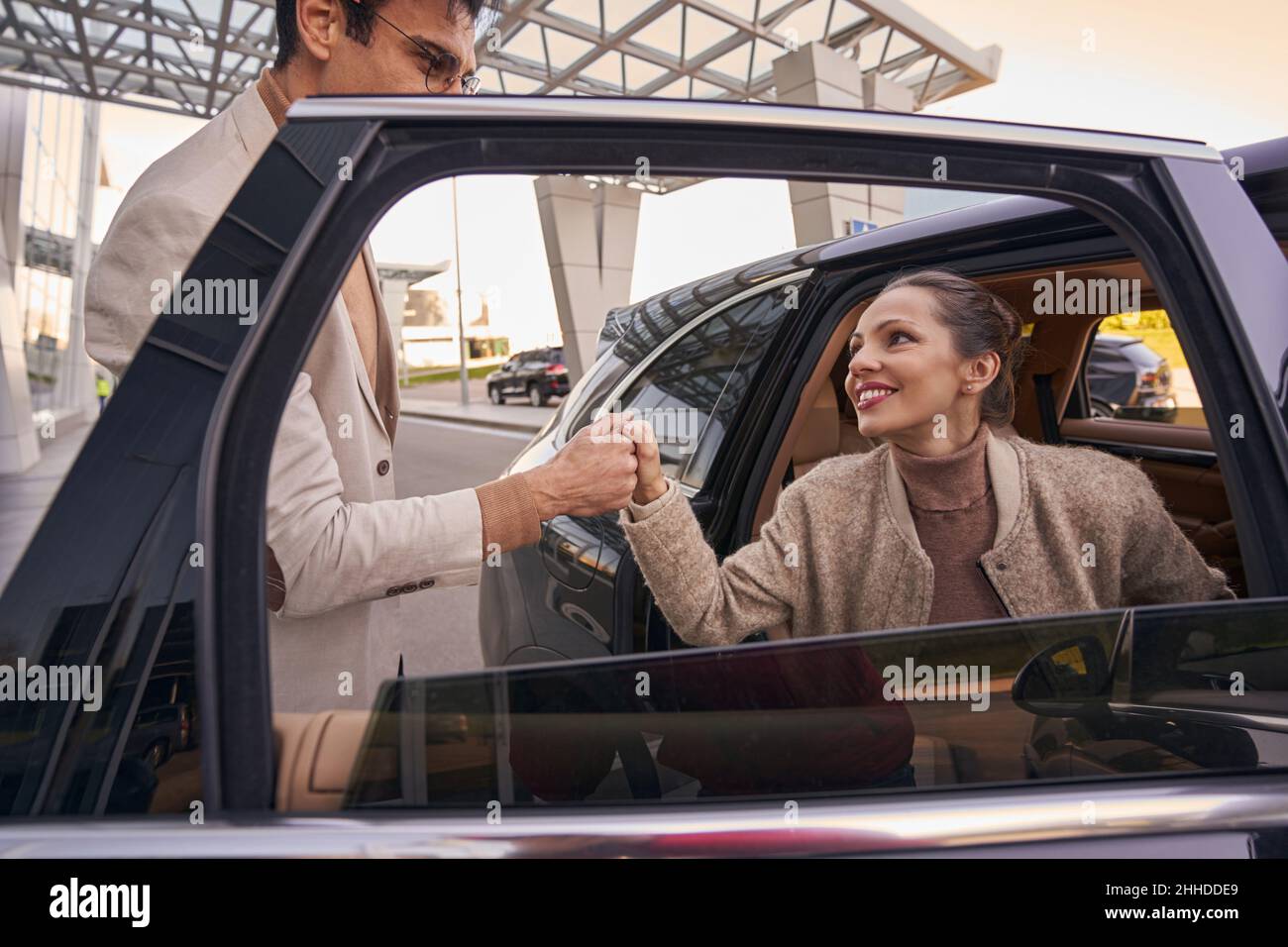 Woman exiting car with help of her partner Stock Photo - Alamy