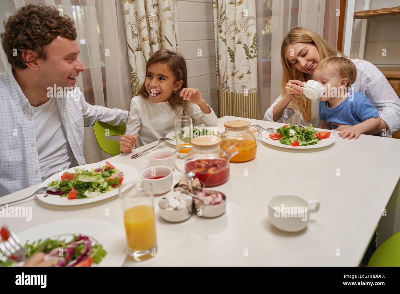 Happy brunette girl laughing at the table Stock Photo - Alamy