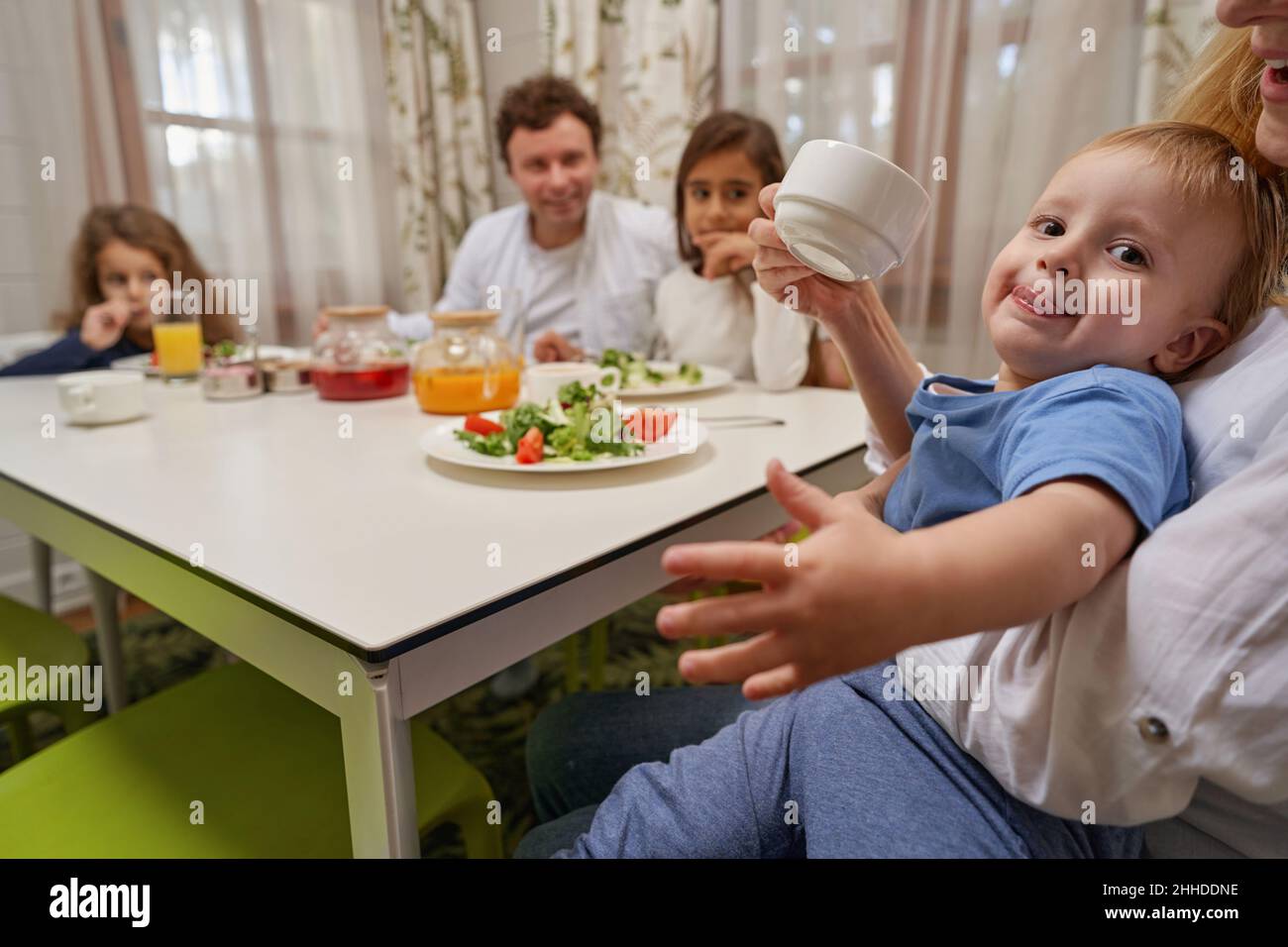 Portrait of kind boy enjoying tasty tea Stock Photo - Alamy