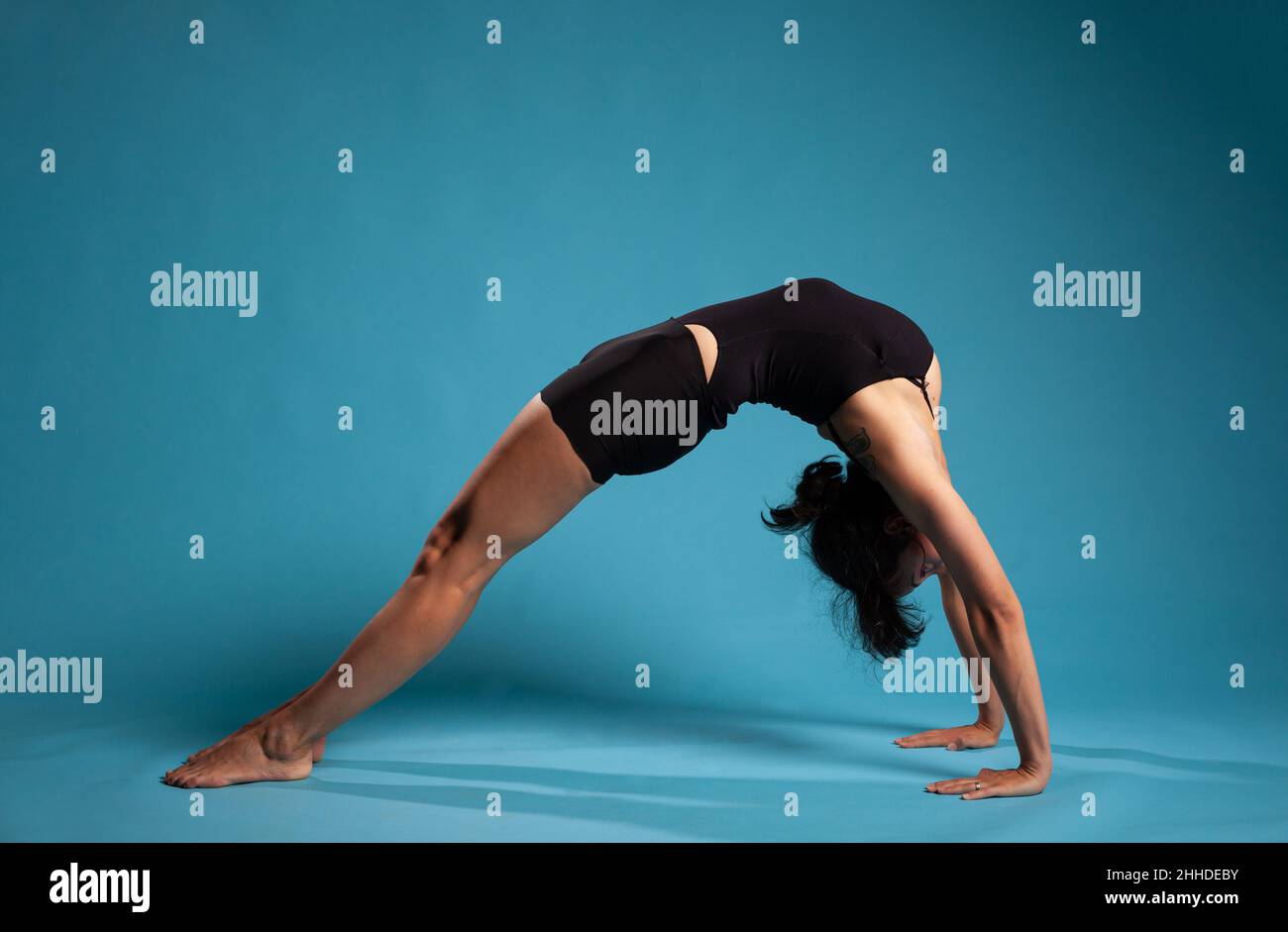 Athletic fitness woman standing in bridge position training body ...
