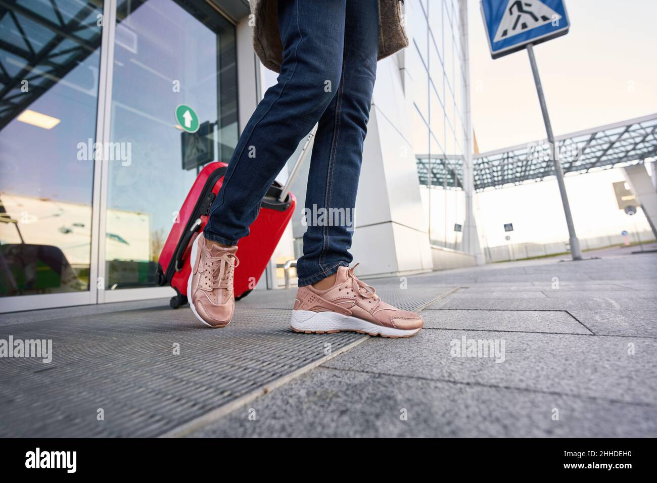 Legs of person near airport door with baggage Stock Photo - Alamy