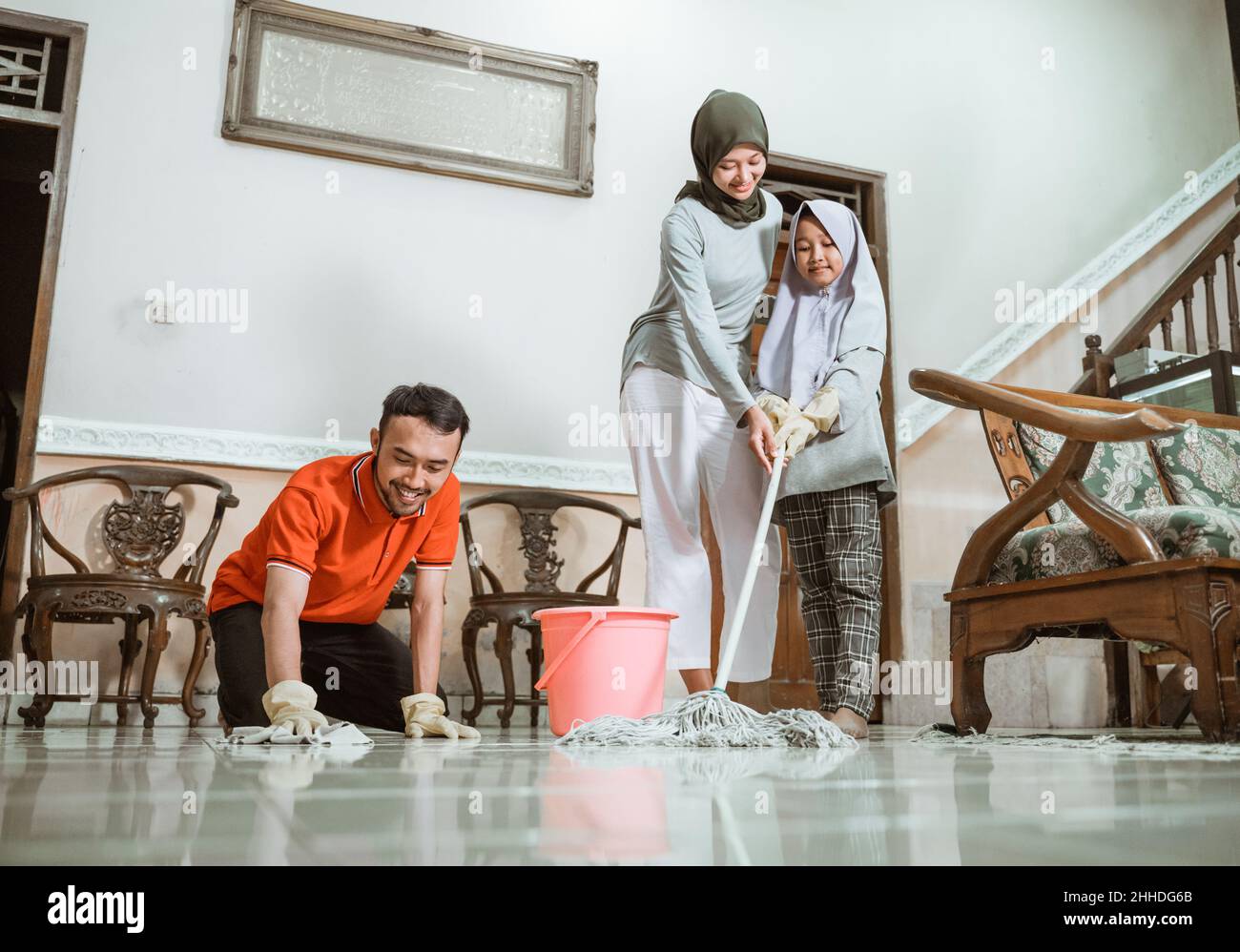 Father, mother and daughter cleaning the floor while mopping Stock ...