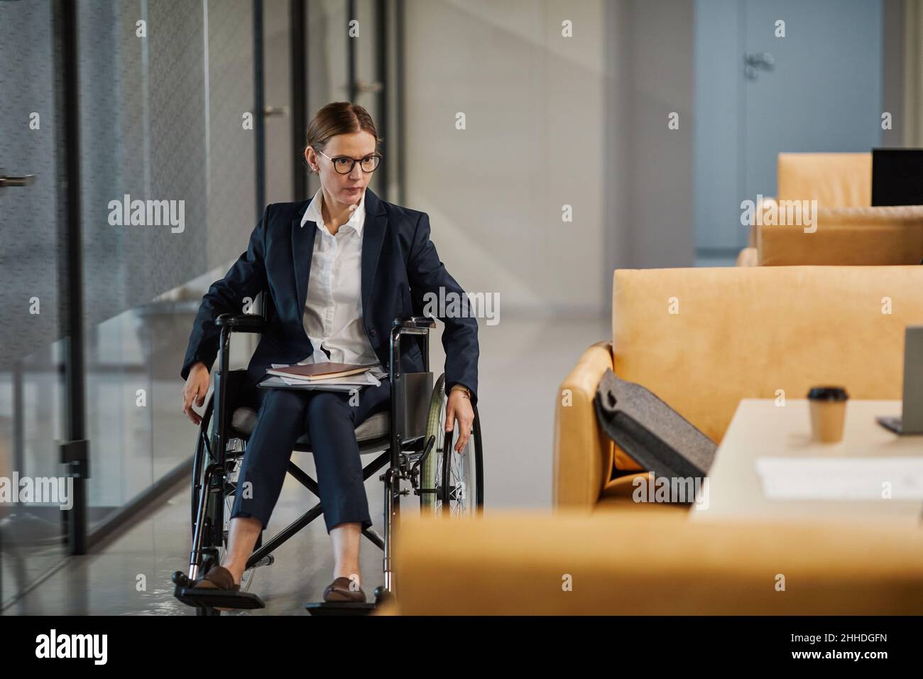 Full length portrait of successful businesswoman using wheelchair in ...