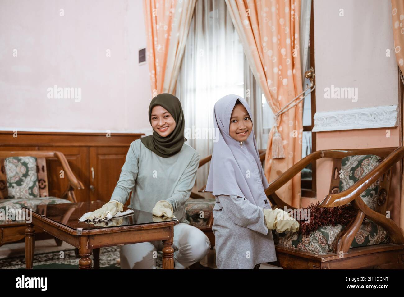 Mother in veil and daughter dusting with rags and magic Stock Photo - Alamy