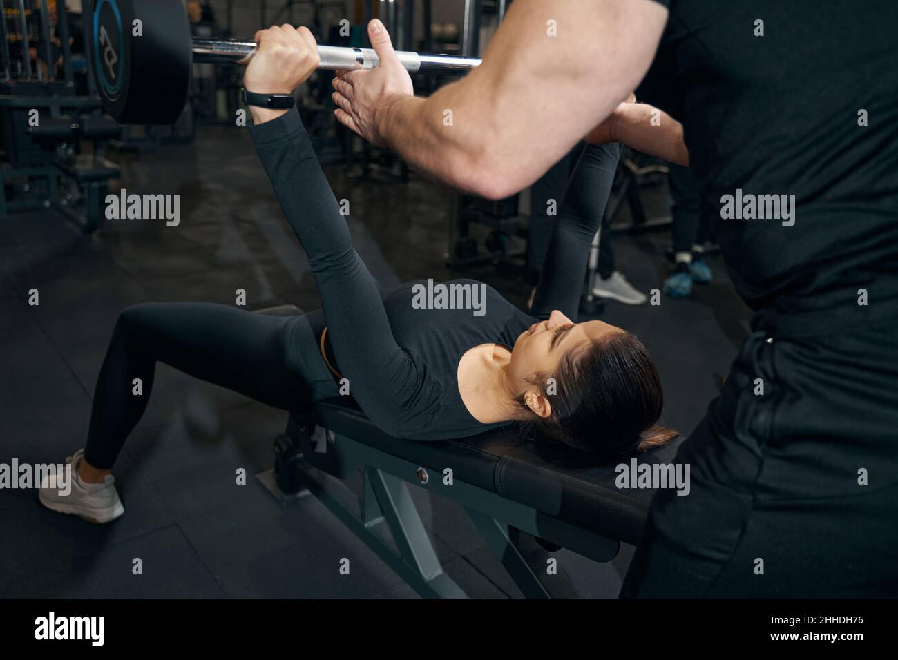 Beginner weightlifter training with professional fitness instructor ...