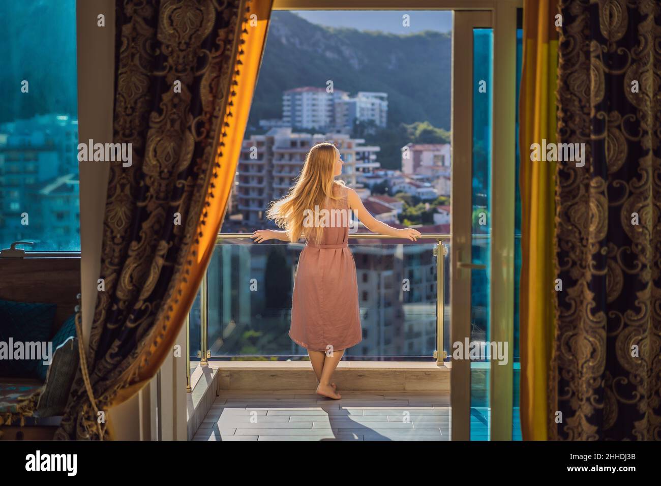 Woman on the balcony against the backdrop of mountains and city, Montenegro. life terrace pretty ...