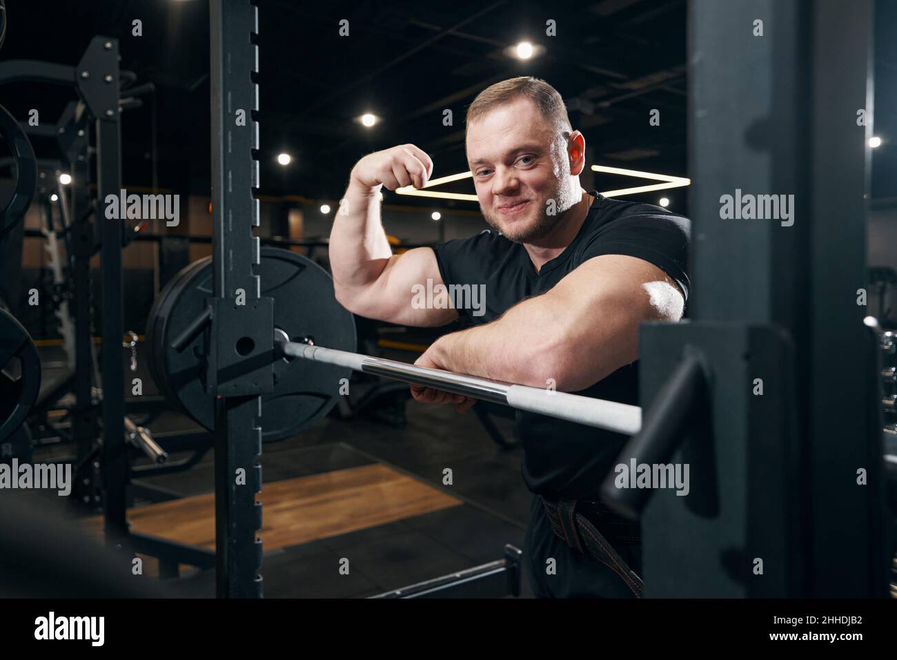 Smiling bodybuilder showing his strength during gym photo shoot Stock ...