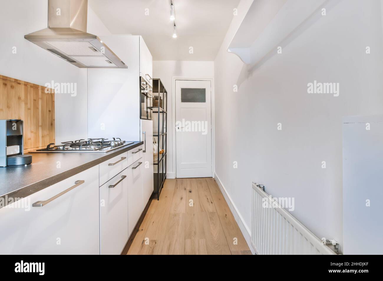 Amazing long kitchen with wooden floor and white kitchen set Stock ...