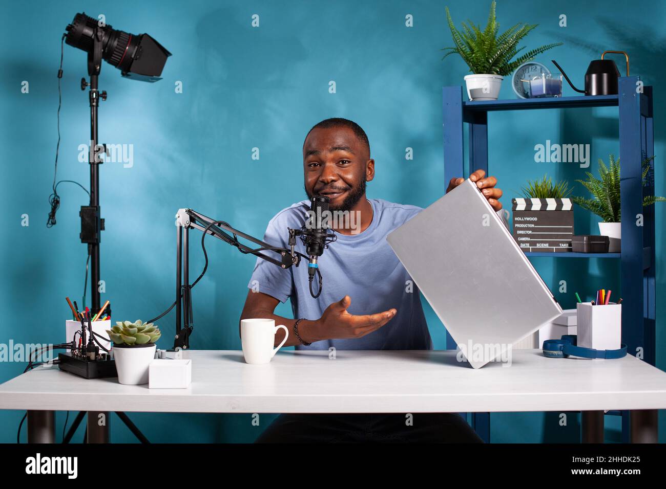 Smiling vlogger holding laptop computer doing online giveaway in ...