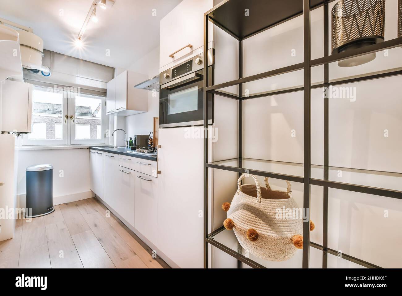 Amazing long kitchen with wooden floor and white kitchen set Stock ...