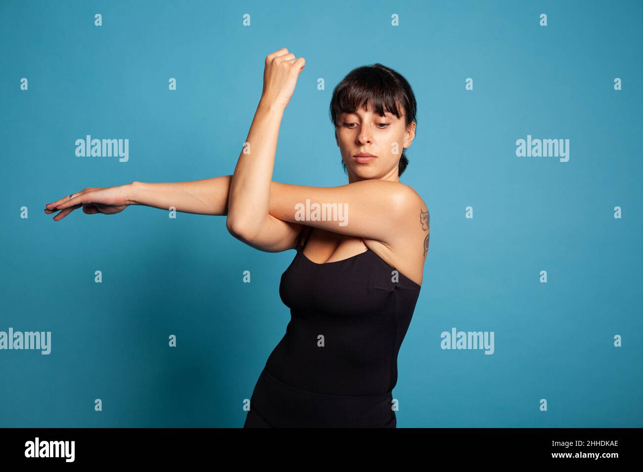 Portrait of fit active woman stretching arm muscles training body ...