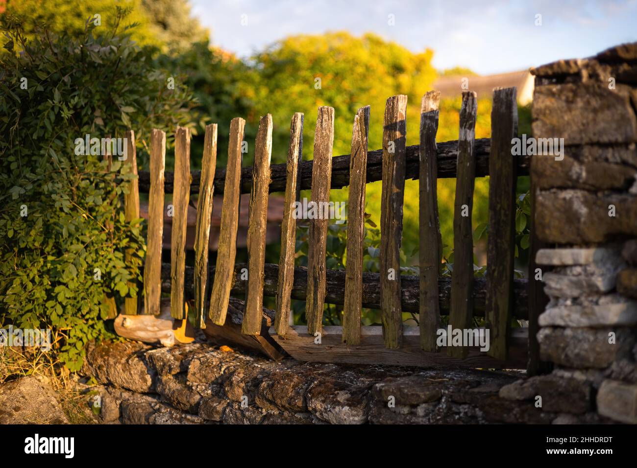 Old wooden picket fence built into a wall from stones Stock Photo - Alamy