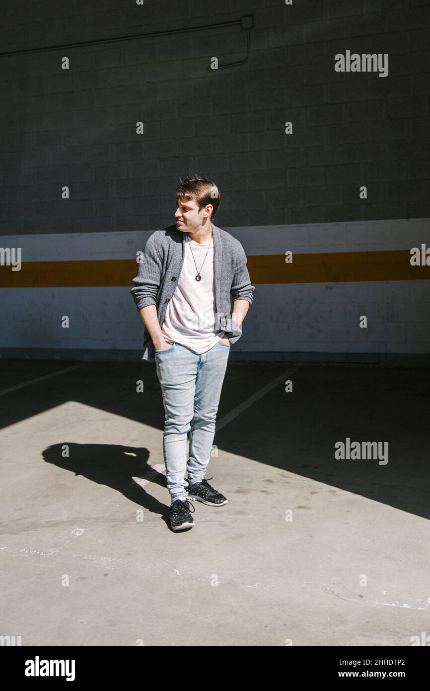 portrait of fashionable cool man walking outdoors with hands his ...