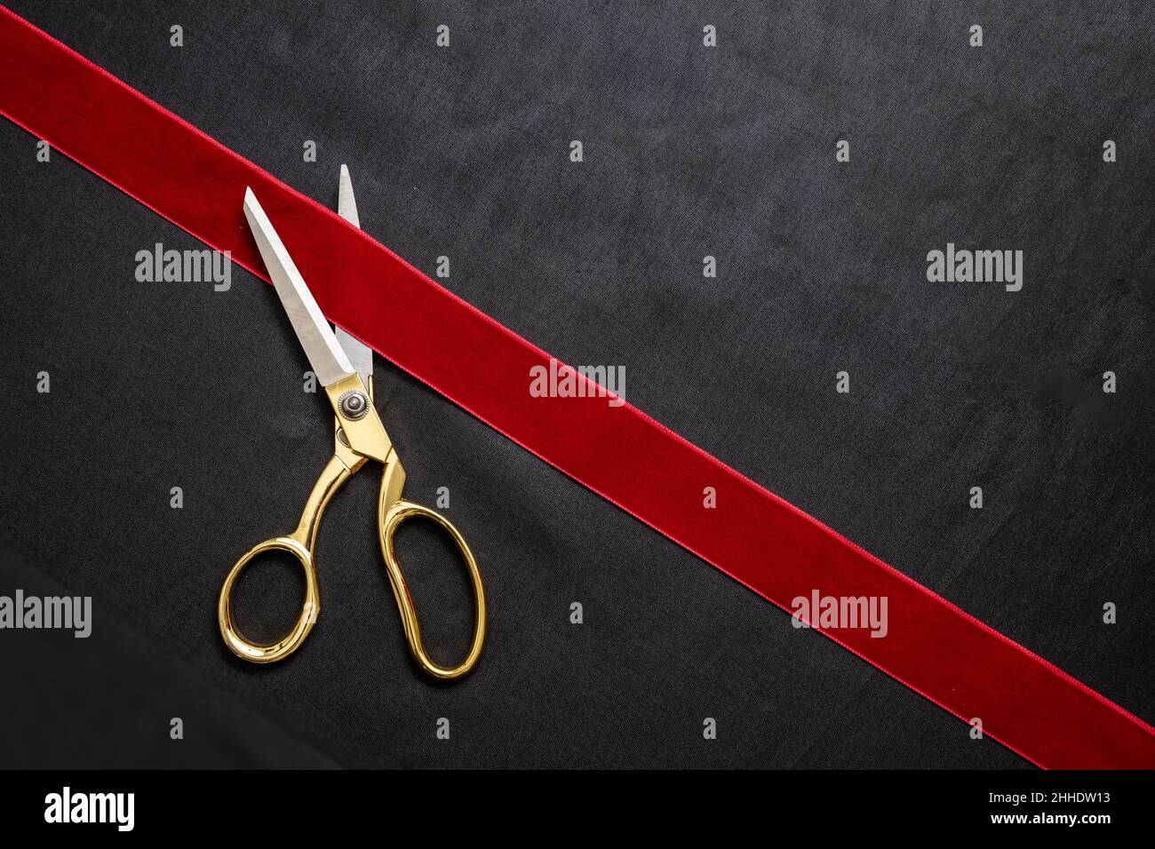 Grand opening, ribbon cut, Gold scissors cutting red velvet ribbon on ...