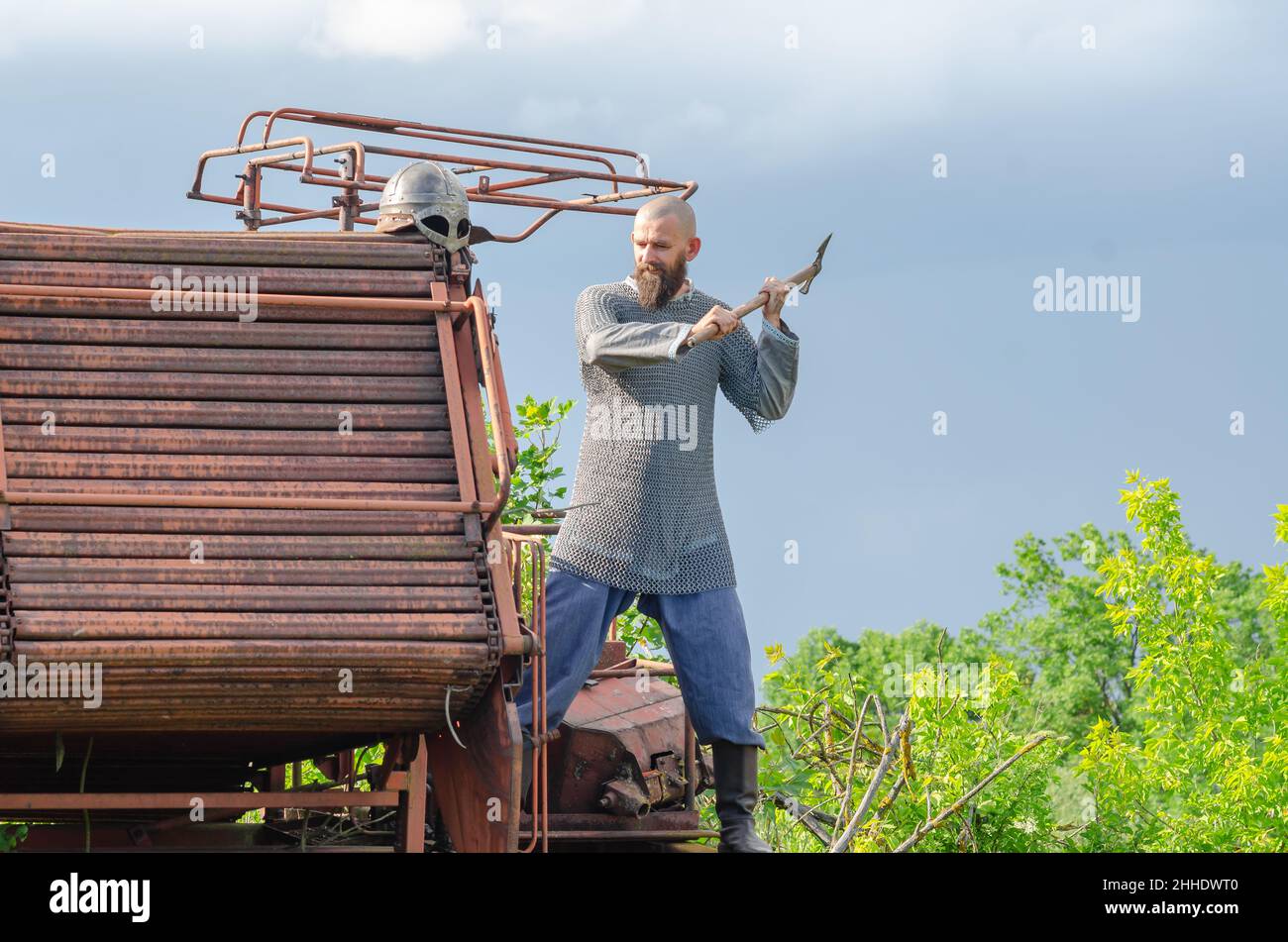 Man in medieval clothes on summer field. Viking armor. Metal helmet and ...
