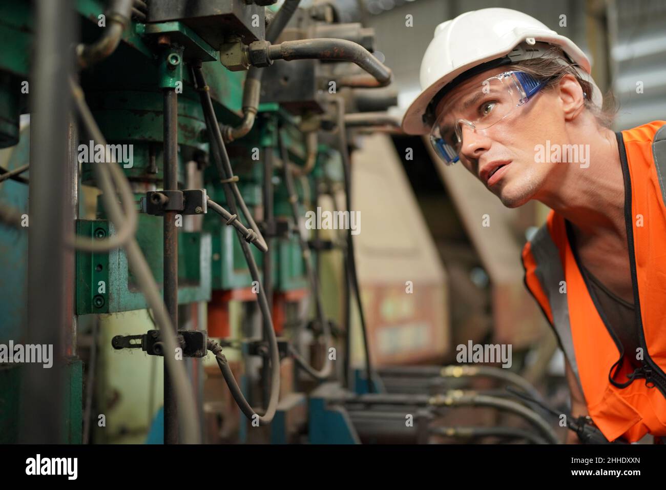 Professional engineer metalworker operating CNC milling machine center ...