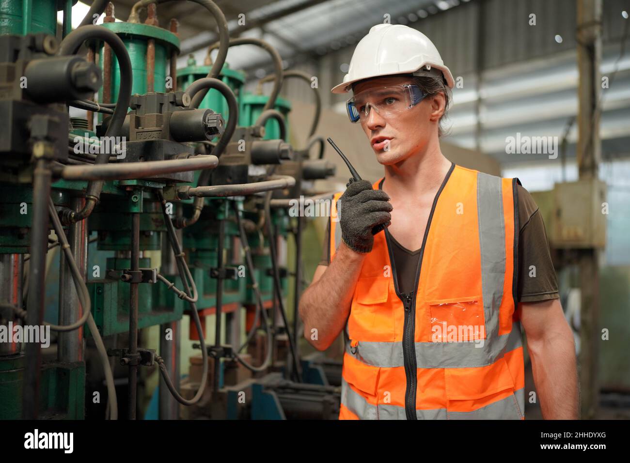 Professional engineer metalworker operating CNC milling machine center ...