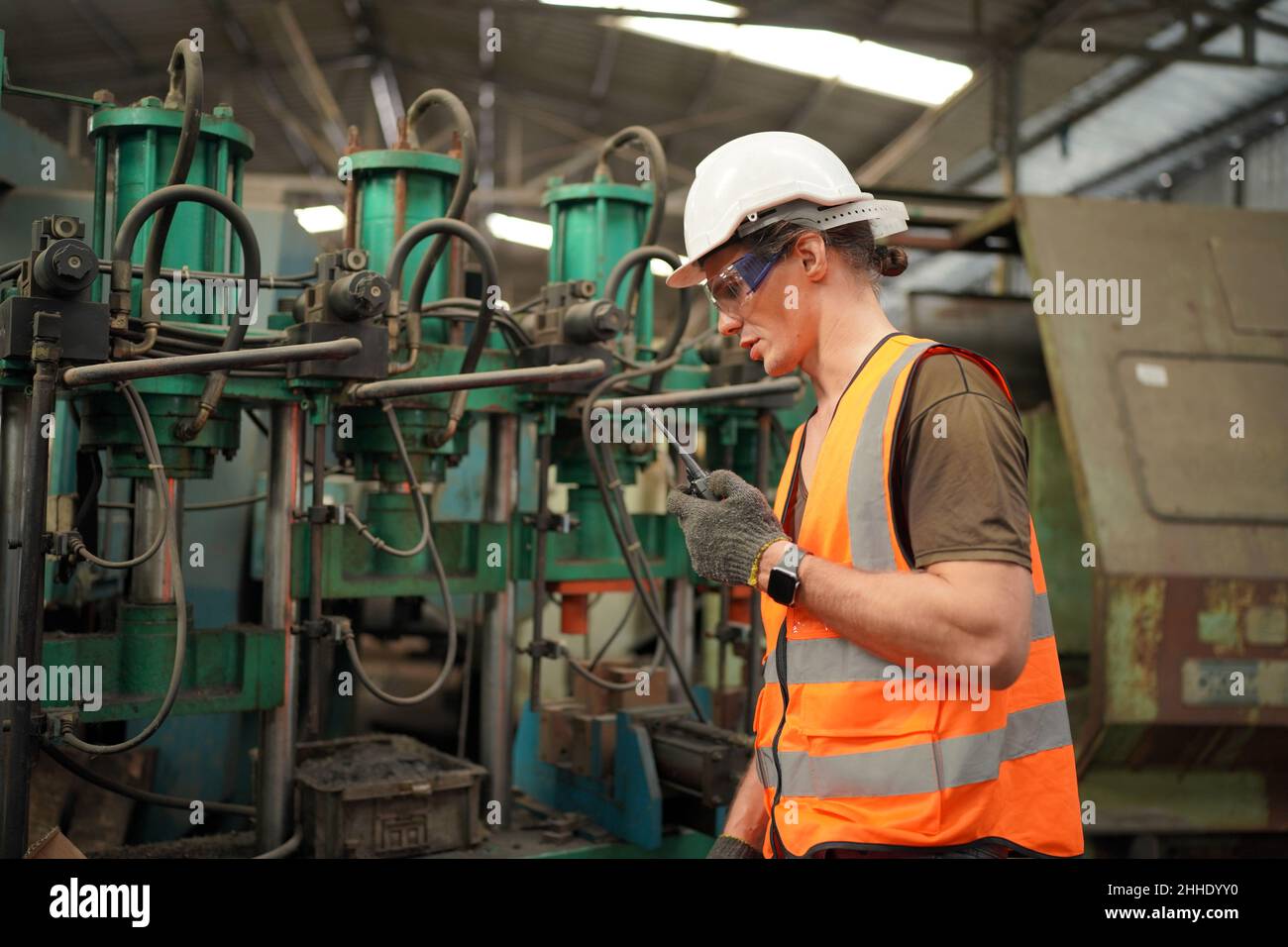 Professional engineer metalworker operating CNC milling machine center ...