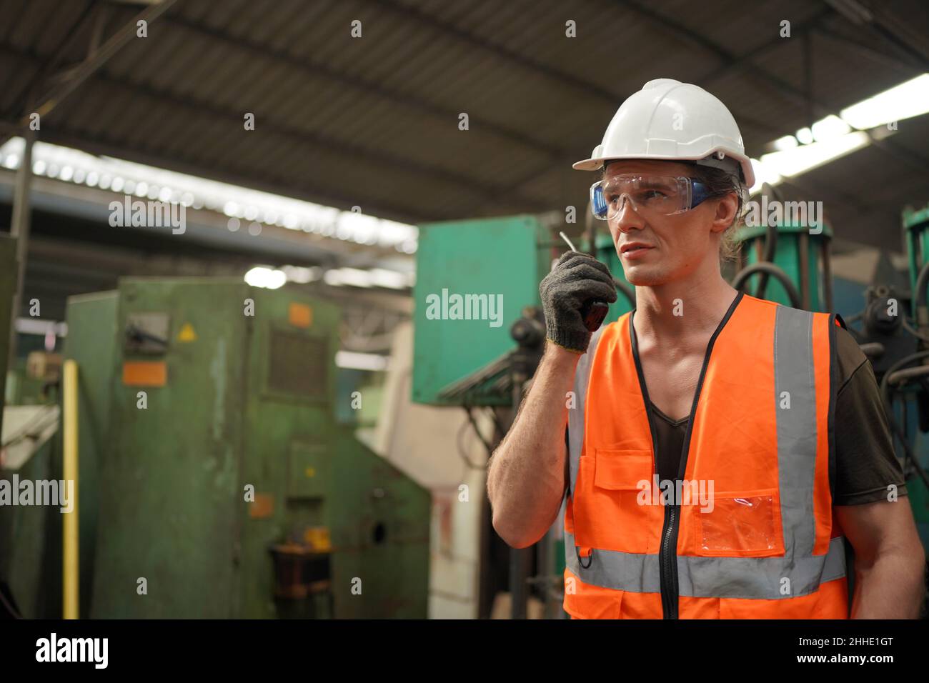 Professional engineer metalworker operating CNC milling machine center ...