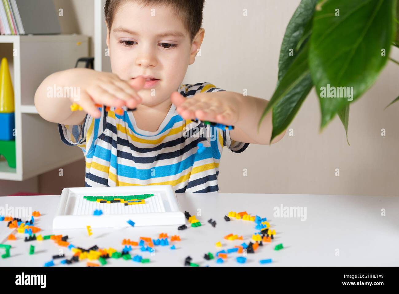 Preschooler child plays with mosaics, small objects for toddlers ...