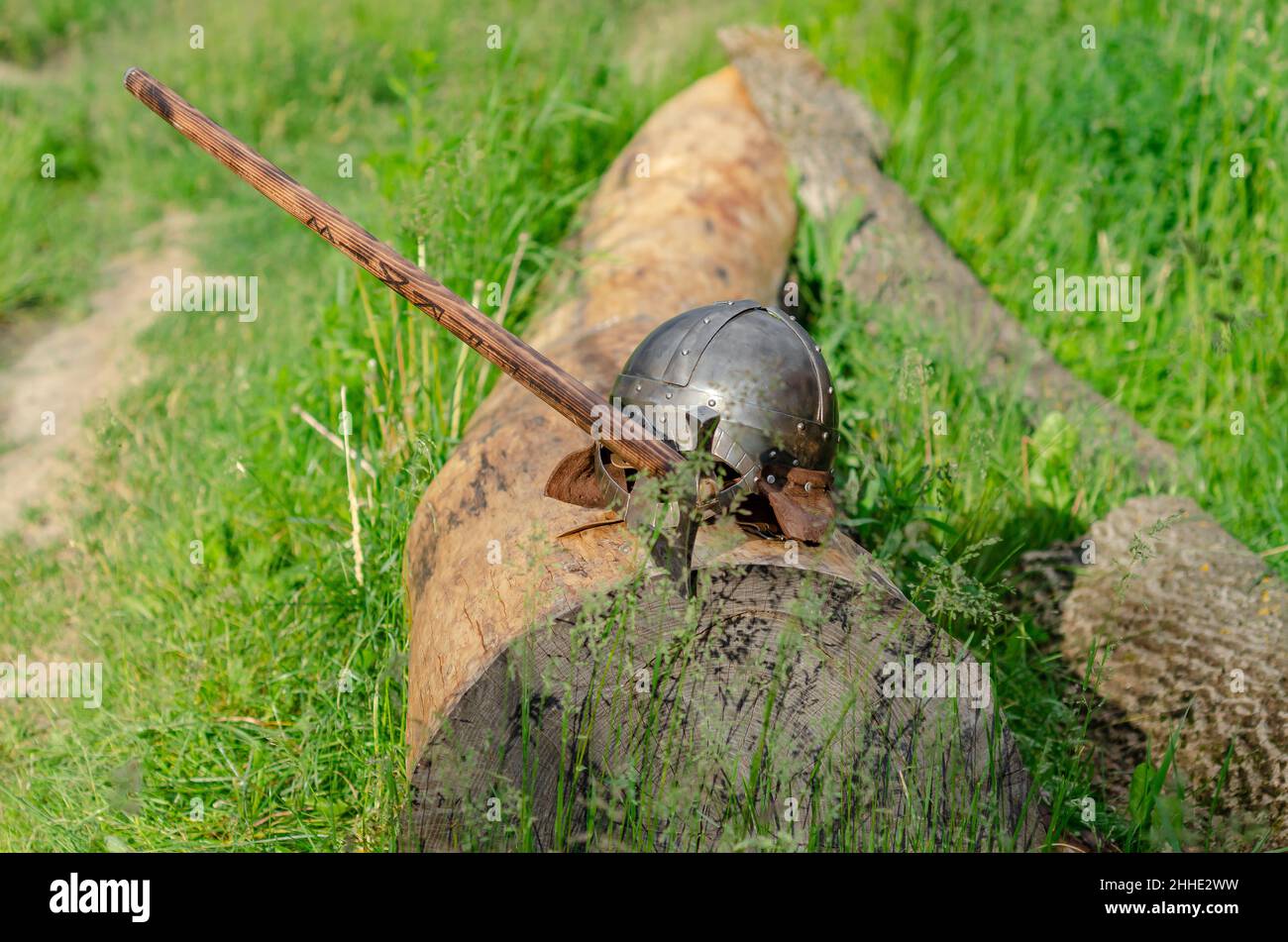 View of ancient Viking armor lying on a wooden log. Helmet and ax ...