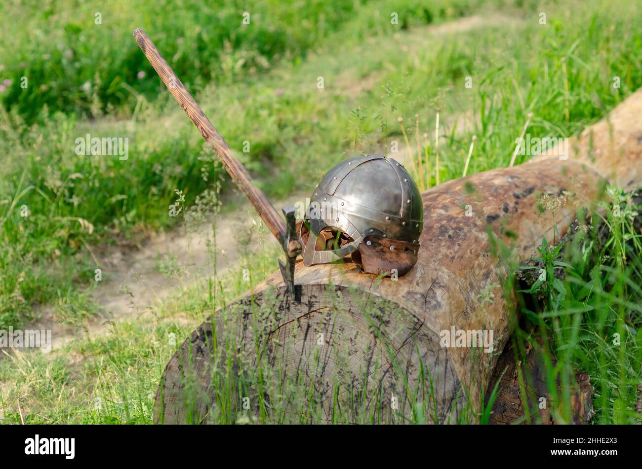 View of ancient Viking armor lying on a wooden log. Helmet and ax ...