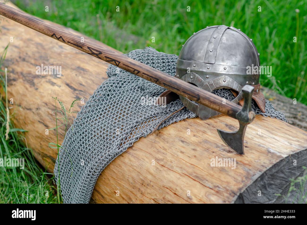 Metal chain mail, helmet and ax lie on wooden log. Viking armor ...