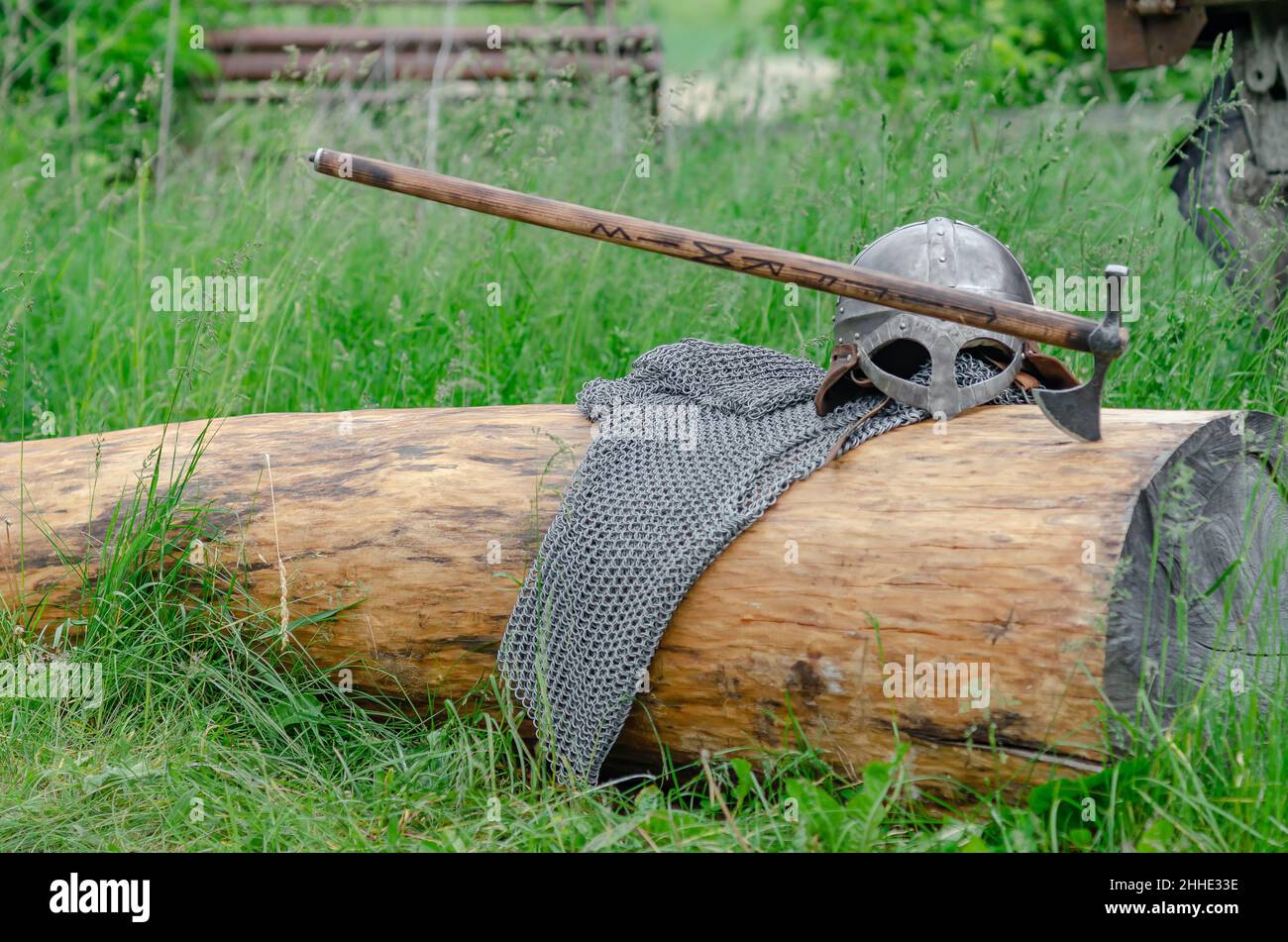 Metal chain mail, helmet and ax lie on wooden log. Viking armor ...