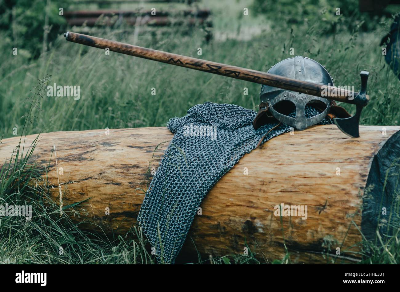 Metal chain mail, helmet and ax lie on wooden log. Viking armor ...