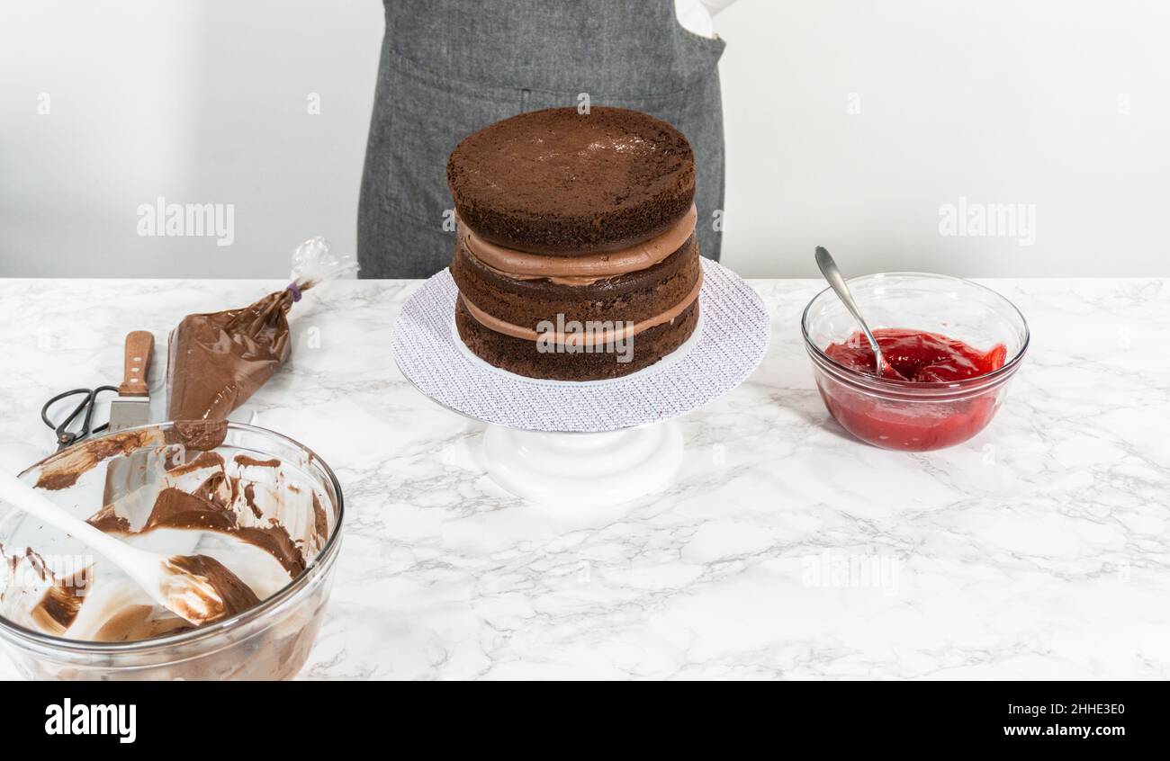 Covering chocolate cake with a crumb layer of chocolate buttercream ...