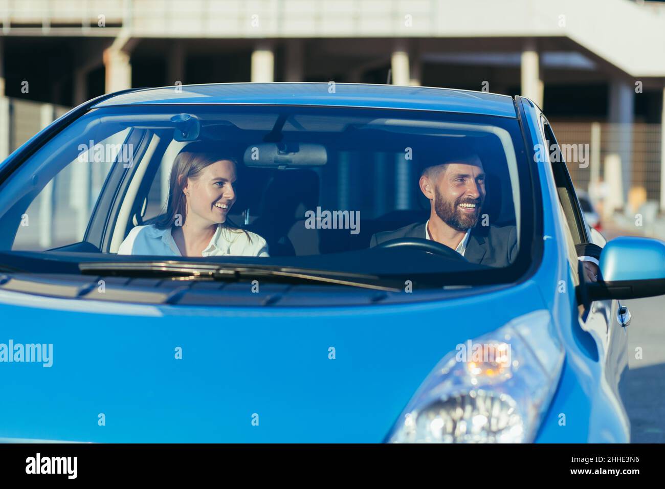 Male driving instructor and female driving school student sitting ...
