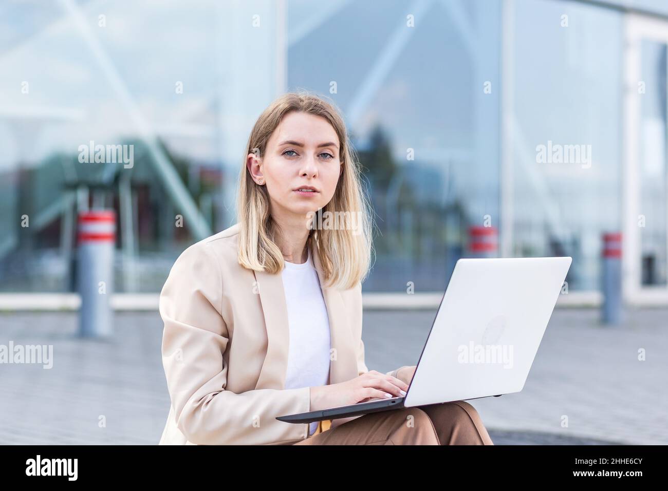 longing young woman sitting alone on street sidewalk on urban ...